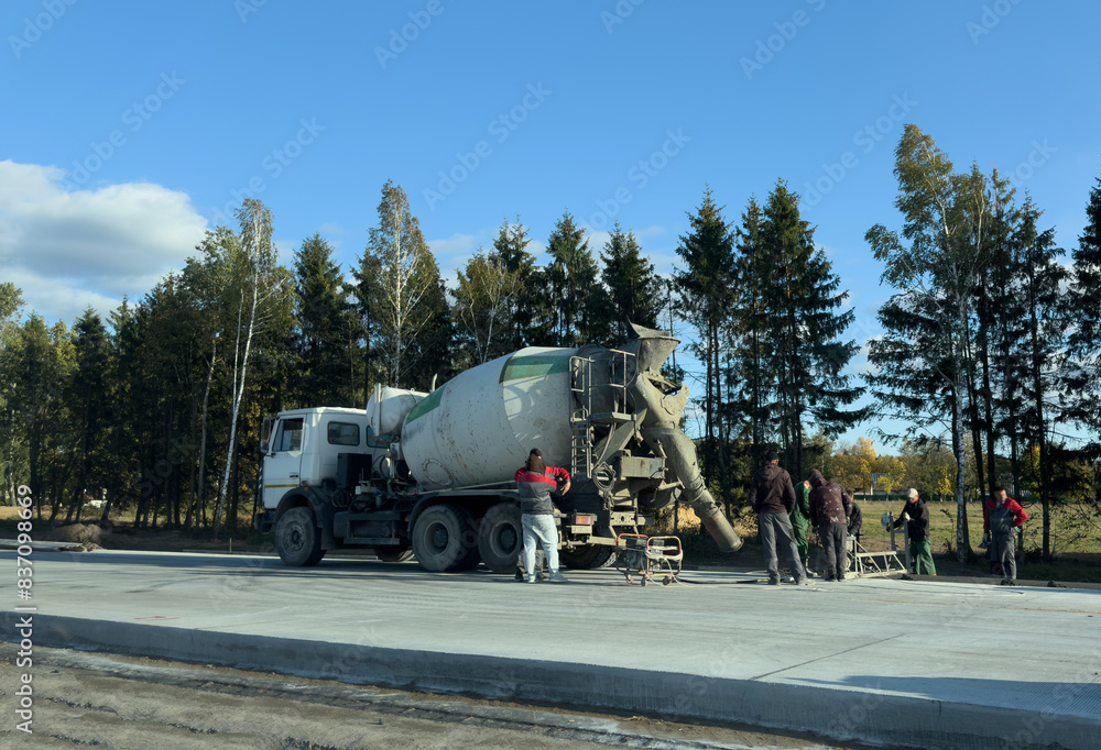 Highway construction. Concrete Paving on road work. Mixer truck on road ...