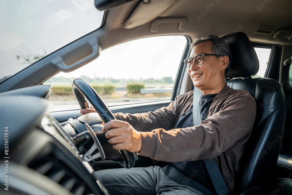 Senior Asian man drives a car vehicle on a clear day. With beautiful ...