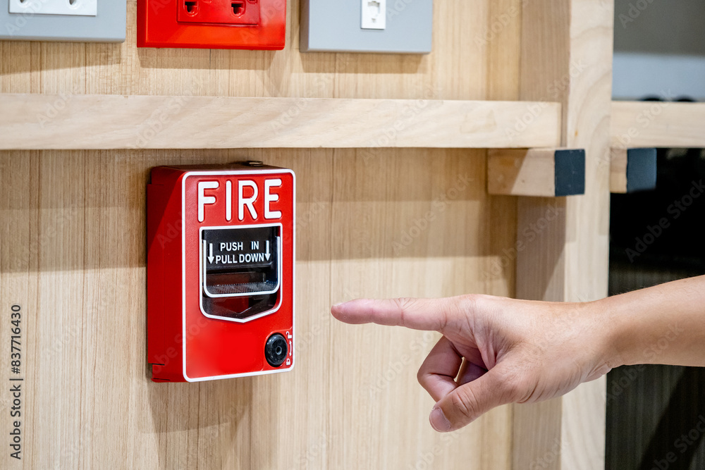 Emergency fire warning system pull station. Hand pointing at red fire ...