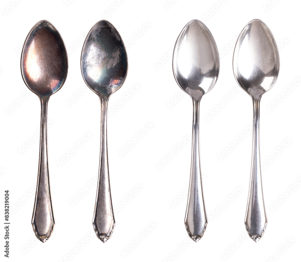 Tarnished and cleaned sterling silver spoons, isolated from above. On ...