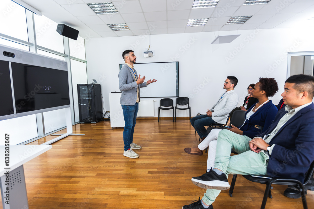 Male CEO standing in front of a multiracial group of colleagues ...