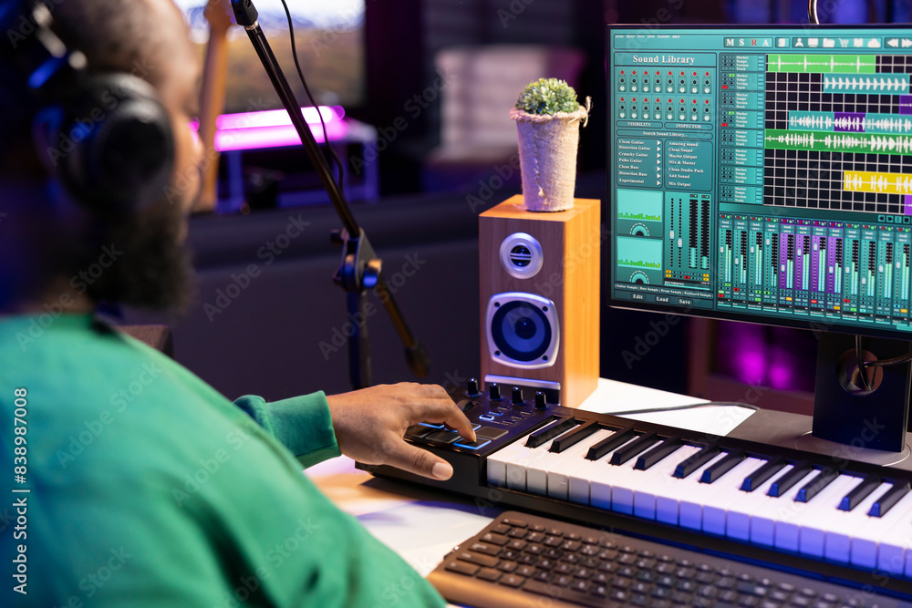 Music engineer adding synthesizer notes over his audio files in home ...
