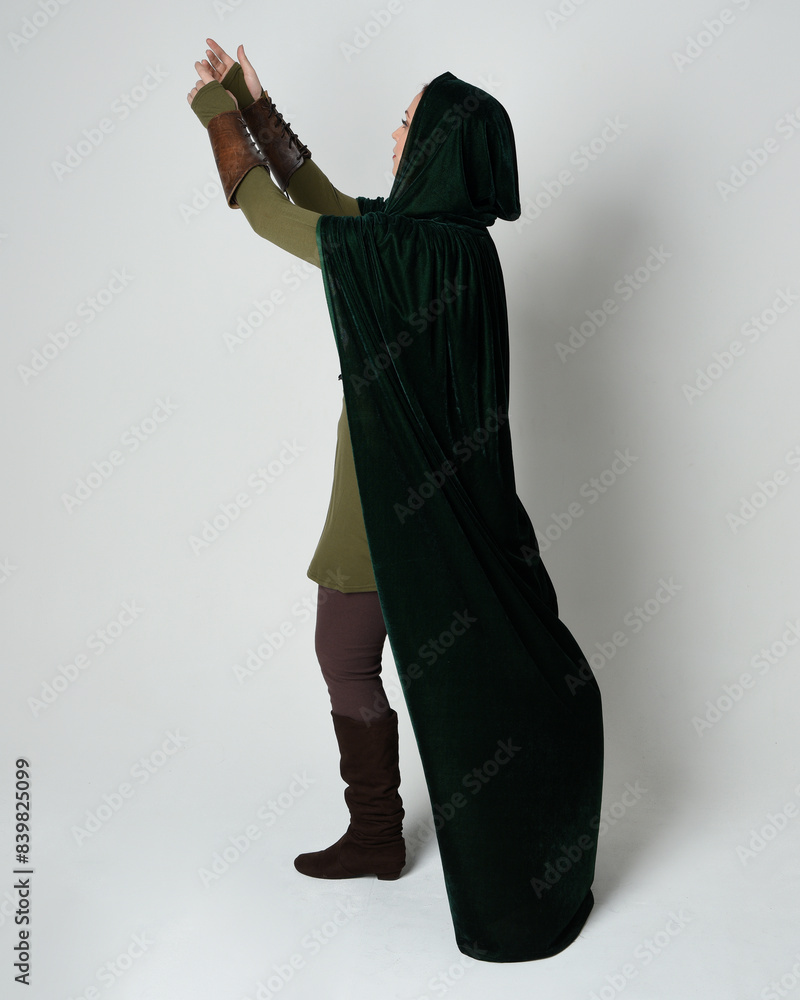 Full length portrait of red haired female model, wearing green medieval ...