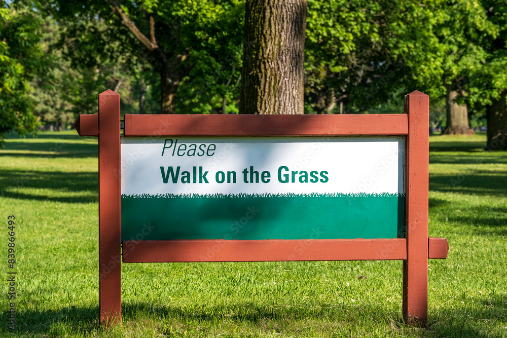 signage: Please walk on the grass green letters on a white background ...