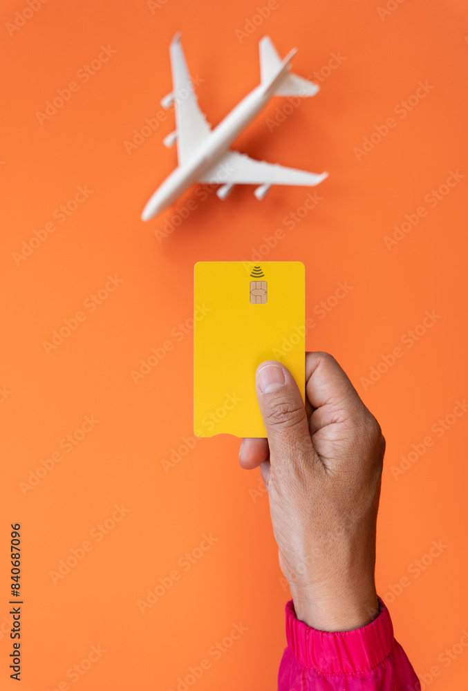 Vacation budget spending concept. Top view of hand holding yellow debit ...