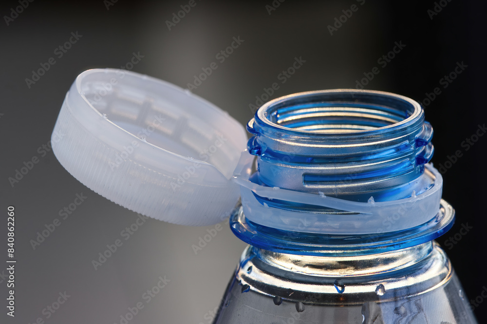 Close up of new cap attached to plastic bottle connected to the neck of ...