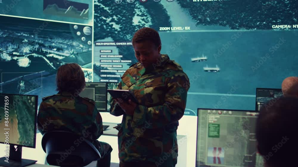 Female military officer supervising radar surveillance footage to input ...