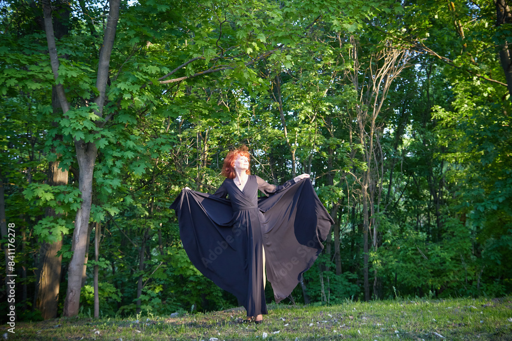 Elegant senior mature Woman dancing in Black Dress in green park. Woman ...