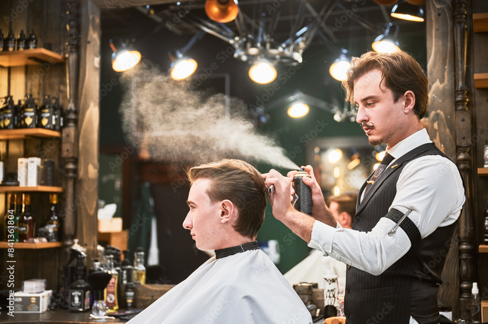 Professional barber using hairspray to finish hairstyle. Stylish ...