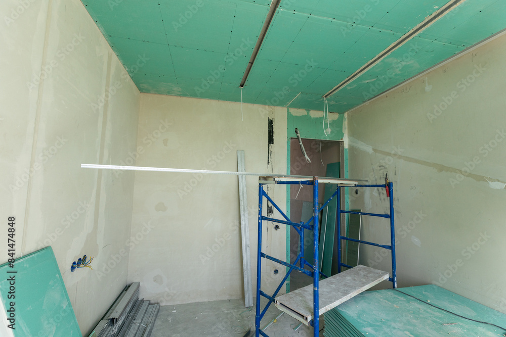 Drywall installation work in progress by construction workers at ...