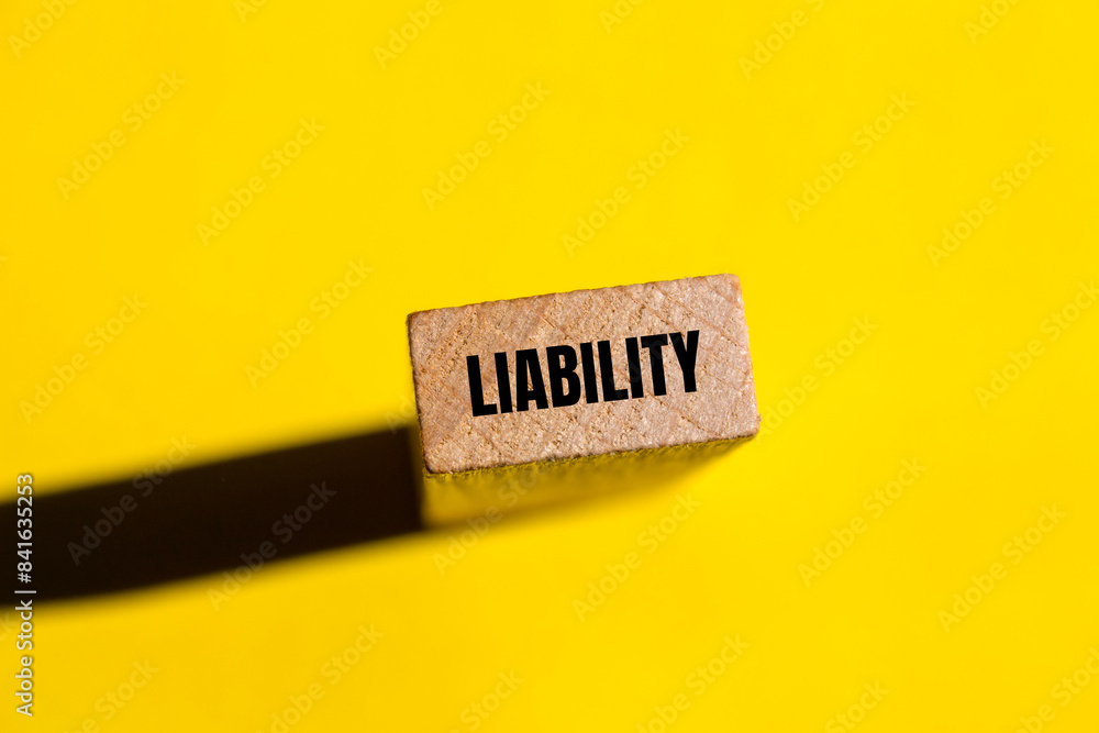 Liability message written on wooden block with yellow background ...
