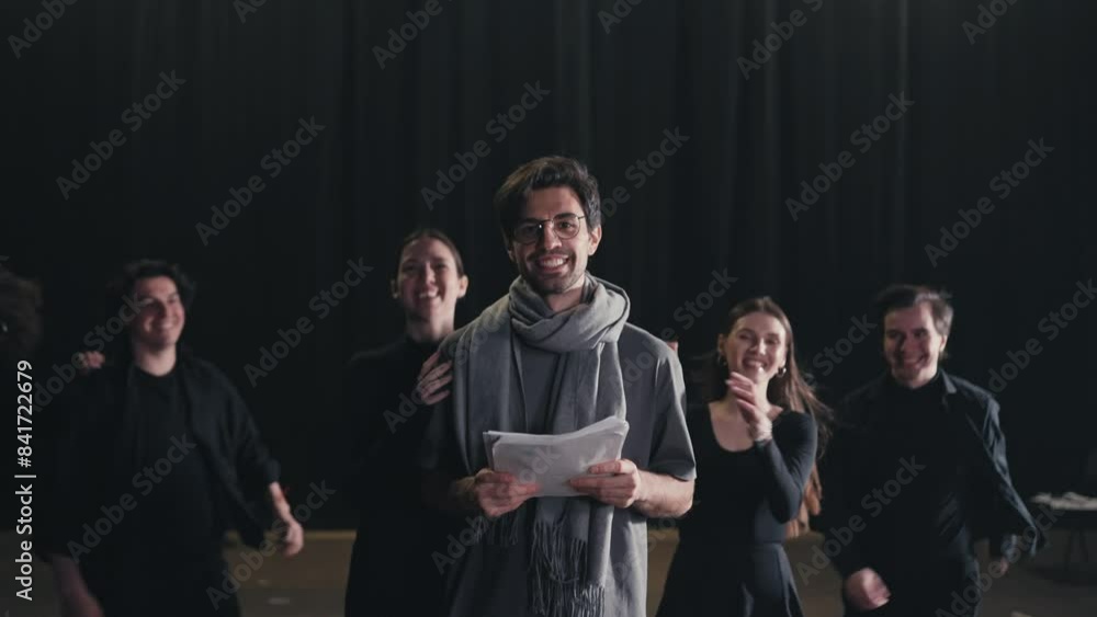 Portrait of a happy young stage director in a gray T-shirt and a scarf ...