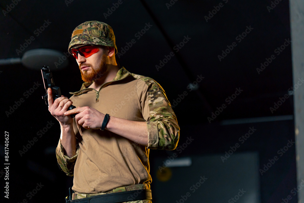 at a professional shooting range a military trainer reloading a pistol ...