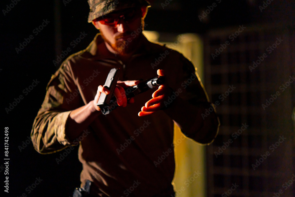 at a professional shooting range a military trainer reloading a pistol ...