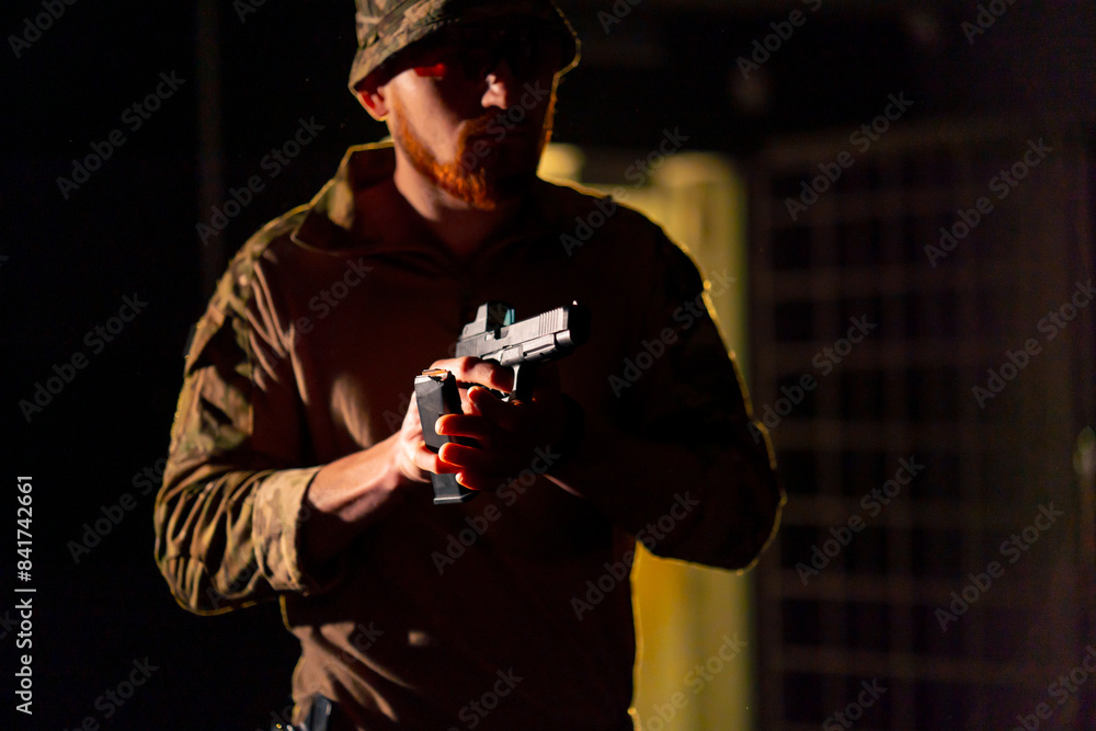 at a professional shooting range a military trainer reloading a pistol ...
