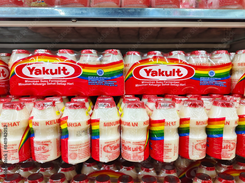 bottles of Yakult probiotic milk on a supermarket shelf. sweet drink ...