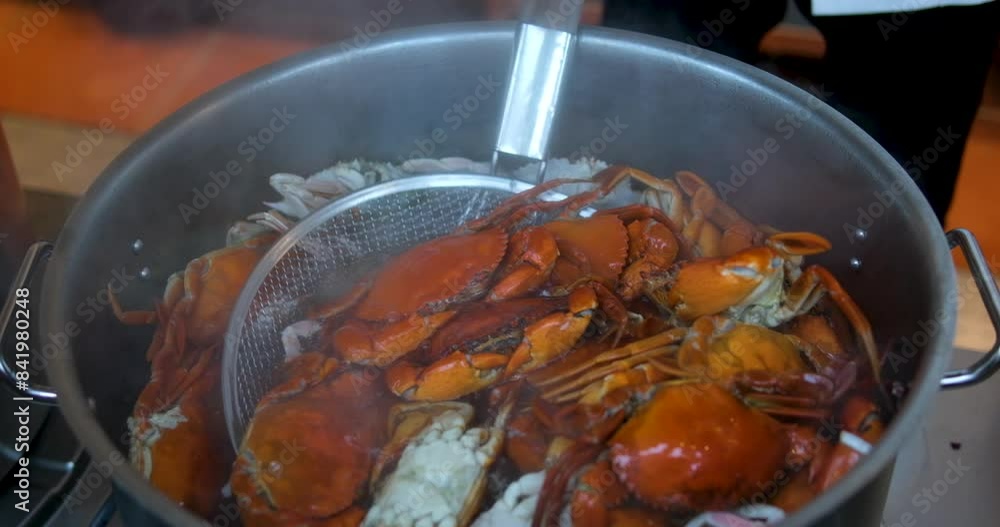female hands cutting up a crab with a special device in a restaurant ...