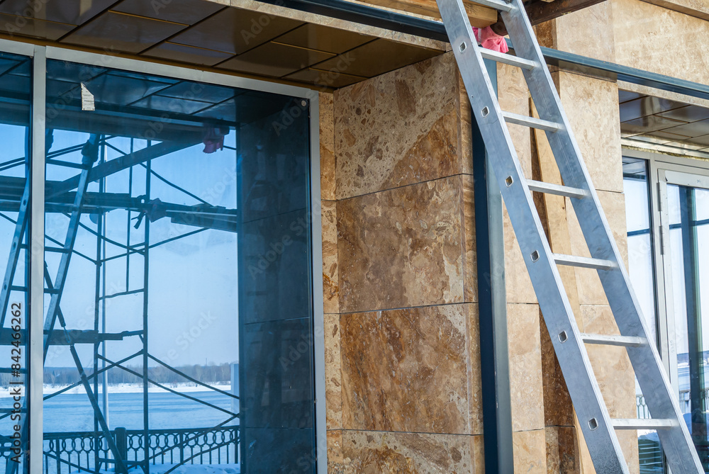 An aluminum alloy construction ladder is attached to the wall for ...