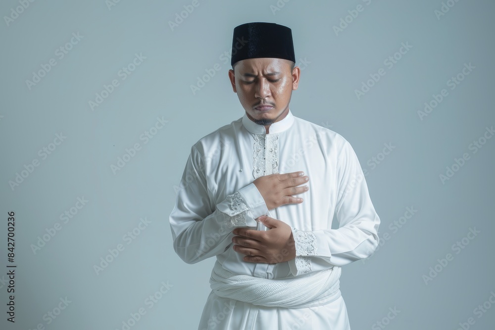 Muslim male standing with stomach pain in an Arabic costume isolated ...