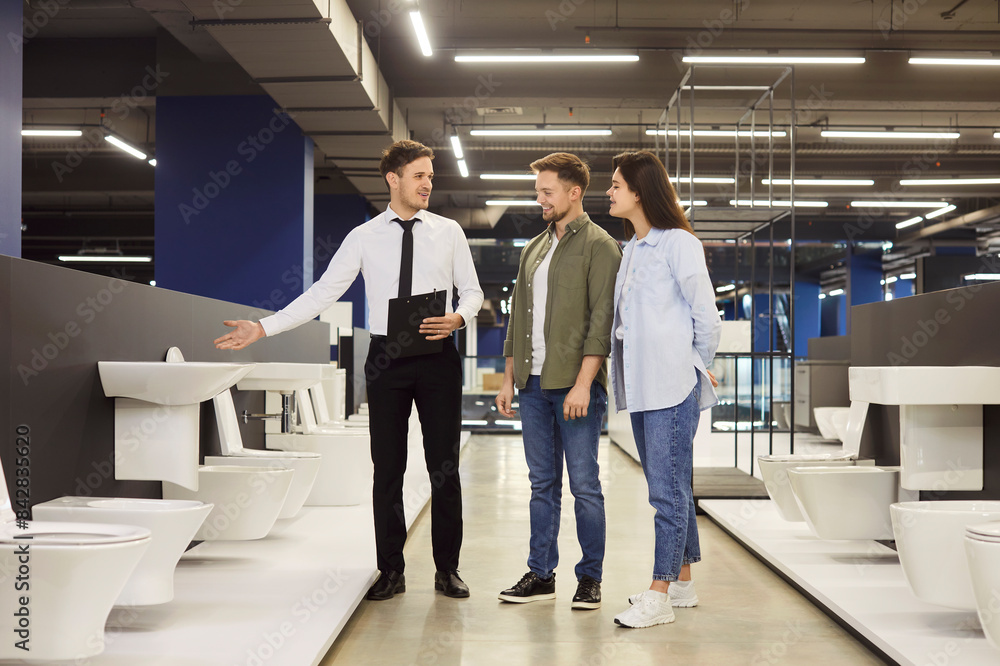 Salesman at retail store showing different bathroom fixtures to ...