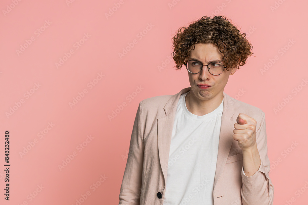 Greedy avaricious Caucasian curly haired man in jacket showing fig ...