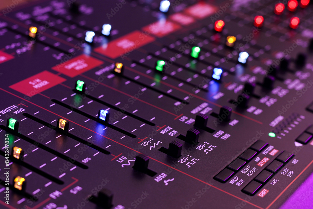 Vintage analog synthesizer showing brightly lit LED sliders, switches ...