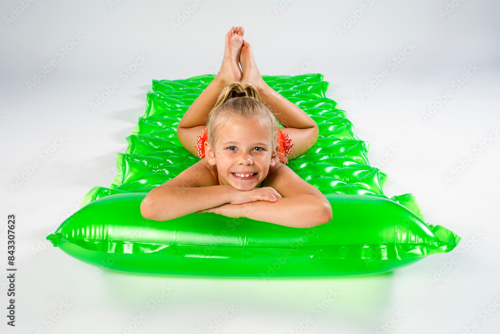 Happy little girl floating on an inflatable raft ready for swimming ...