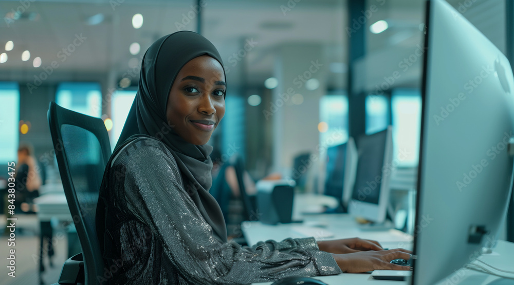 Happy black hijabi woman working on desktop computer in corporate ...