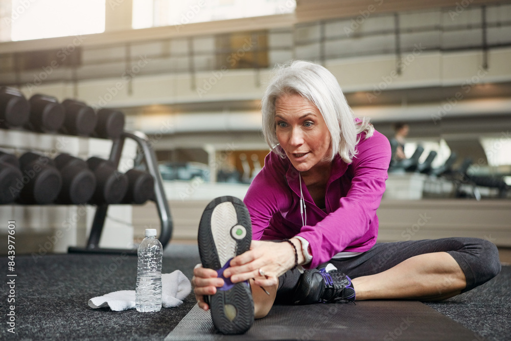 Feet, stretching and mature fitness woman on a gym floor for body warm ...