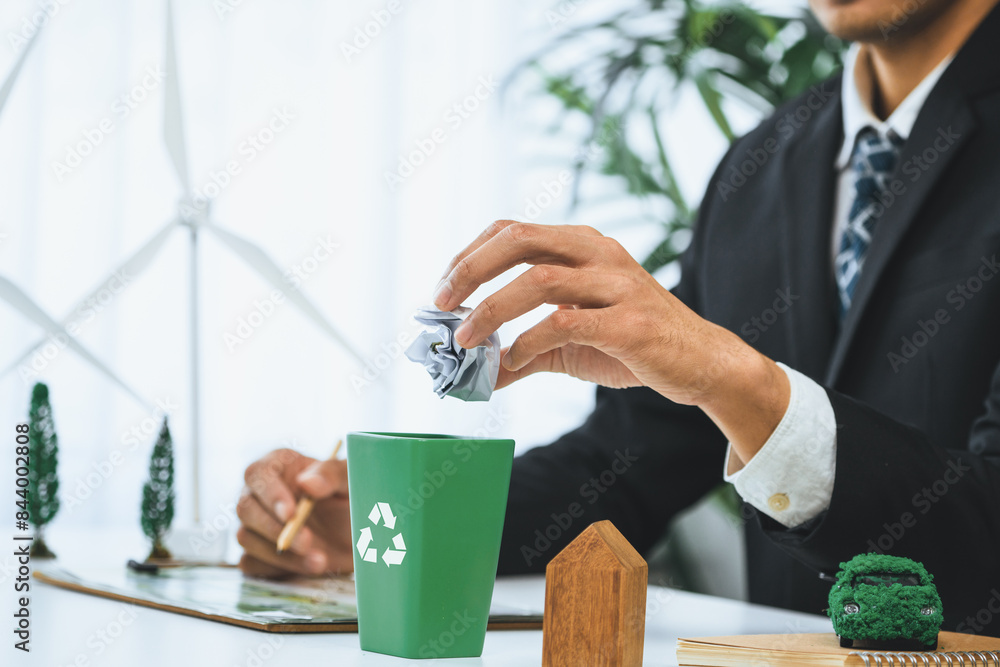 Businessman put paper waste on small tiny recycle bin in his office ...
