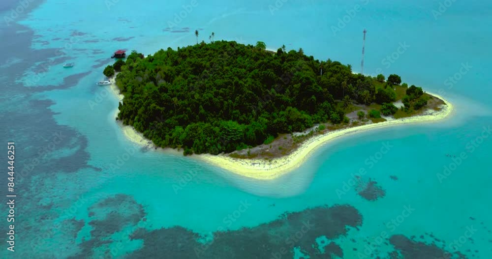 A drone gracefully soars over a stunning island, capturing its ...