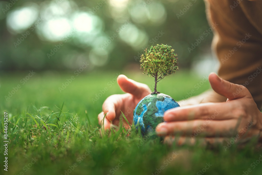 Save our planet, Hand of woman protect tree in the world on green grass ...