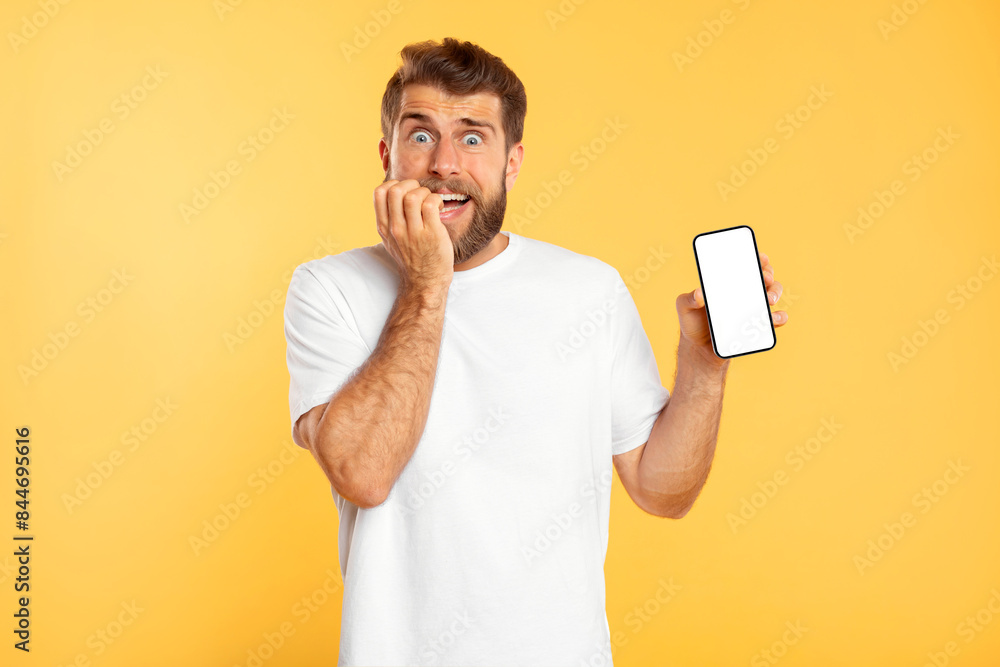 Shocking mobile offer. Emotional European guy holding smartphone with ...