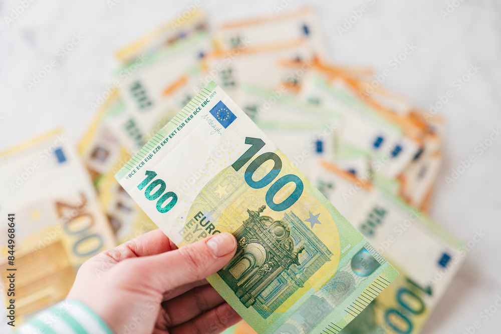 Euro bills on a marble background.one hundred euro banknote in hand ...