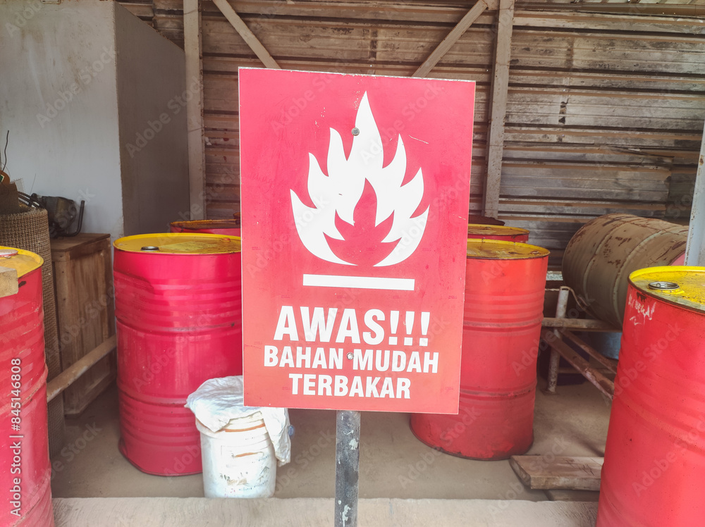 warning board with the words "awas!!! bahan mudah terbakar" in English ...