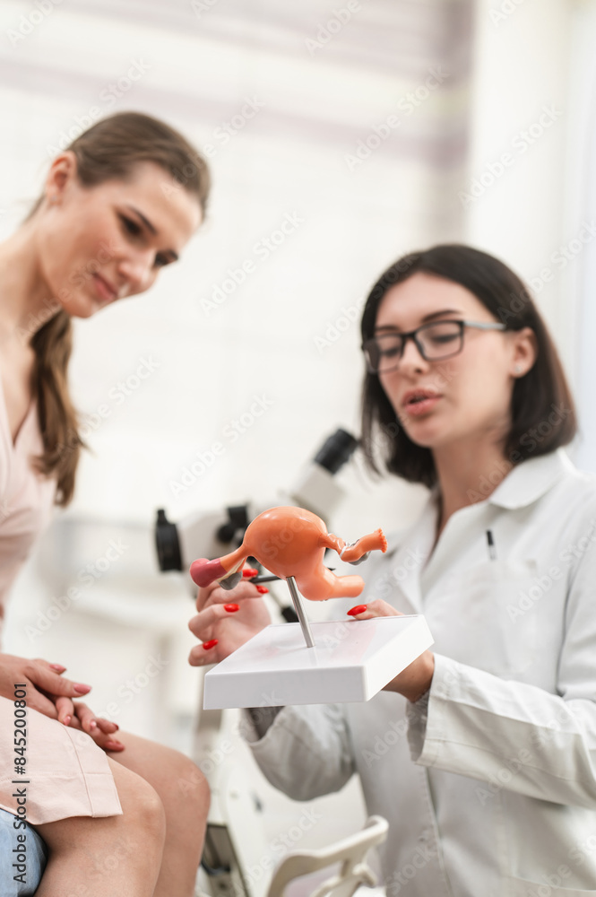 Medical examination in a gynecologist's chair, the doctor shows and ...