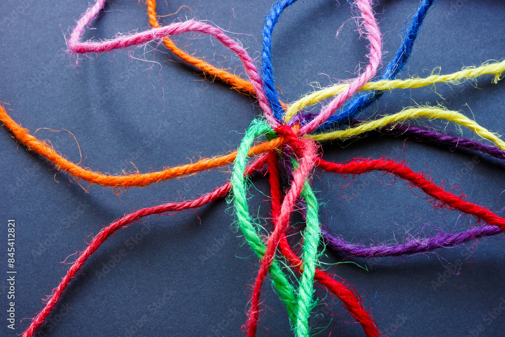 The colored threads are tied together in a knot as an abstract symbol ...