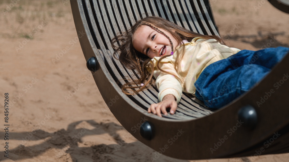 Little girl child rides on a swing. Adorable child resting while lying ...