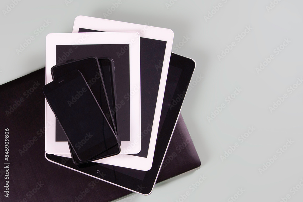 Pile of old used laptop computers, digital tablets, phones on neutral ...