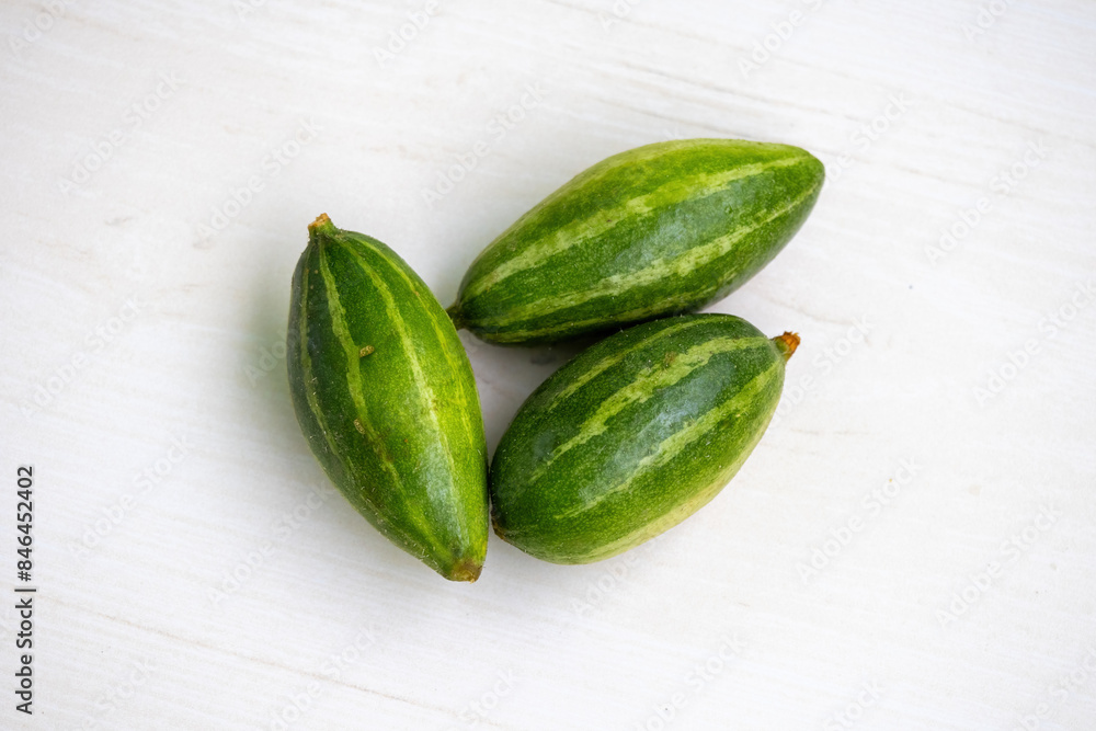 Fresh green vegetable pointed gourd or potol isolated on light wooden ...