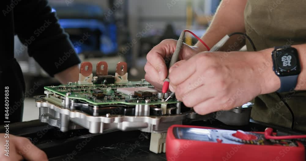 Close-up of a male mechanic using tools to repair and check an electric ...