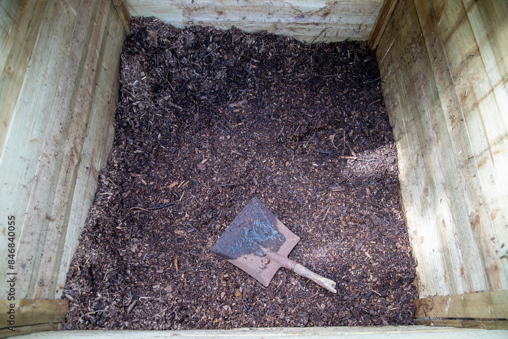 Intérieur d'un grand compost en bois, du compost avec une vieille pelle ...