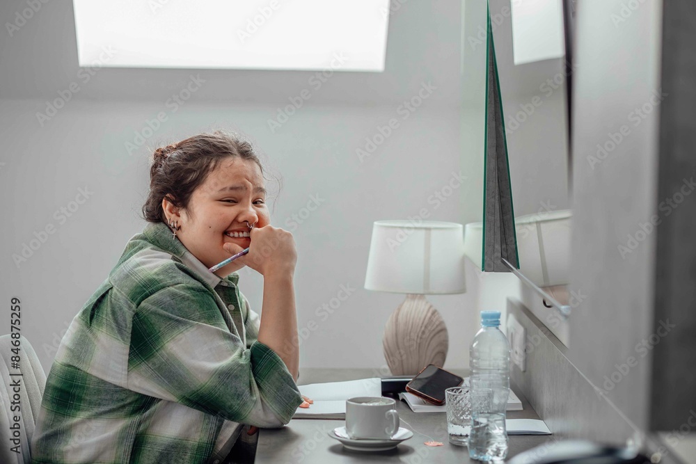 woman smiling while working at her desk, illustrating how a positive ...
