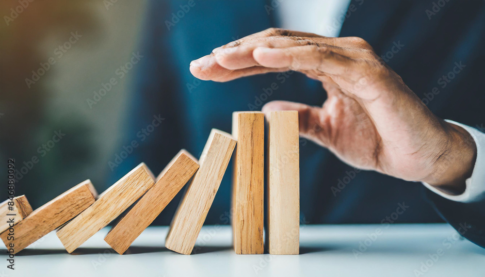 hands preventing a domino effect symbolizes support, intervention, and ...