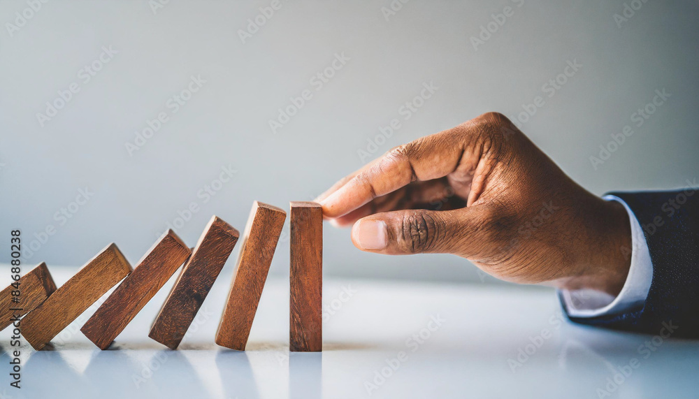 hands preventing a domino effect symbolizes support, intervention, and ...