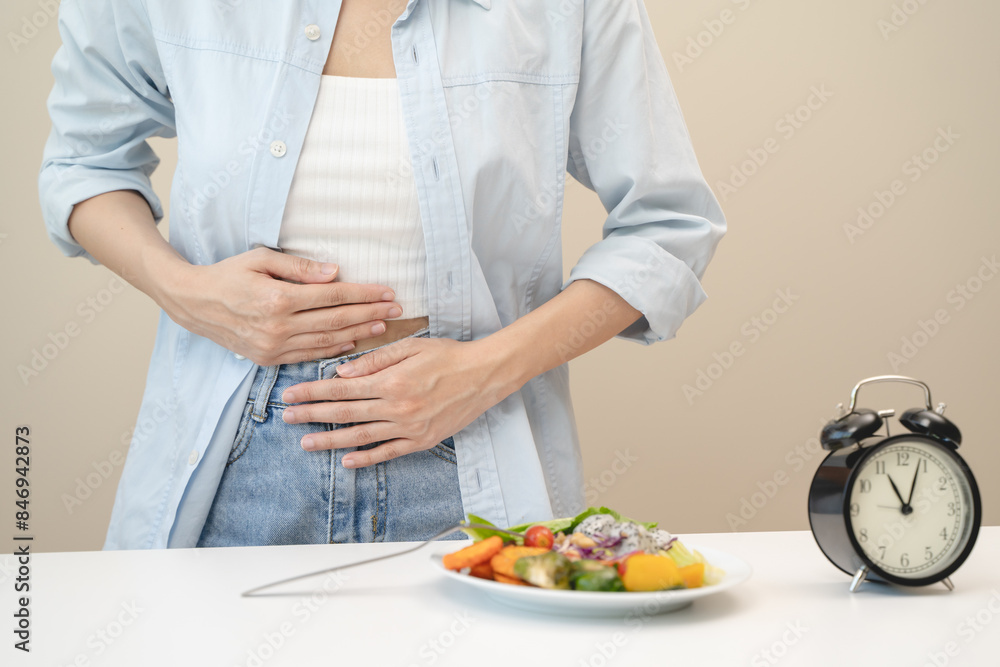 Intermittent fasting concept, Close-up on clock and people feeling ...