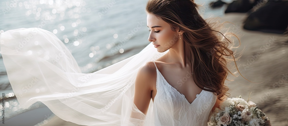 Happy bride in elegant white dress and veil by the sea, with brunette ...