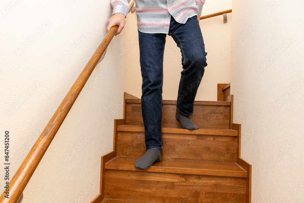 手すりを握って階段を下りる人物 Stock Photo | Adobe Stock