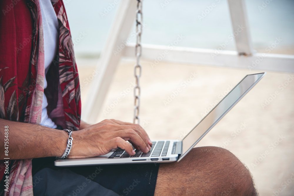 Man traveler use laptop on summer beach blue sky. Asian man wear casual ...