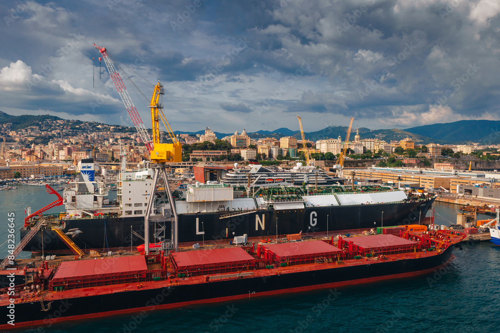 The photo captures a vibrant and bustling scene of Genoa harbor, bathed ...